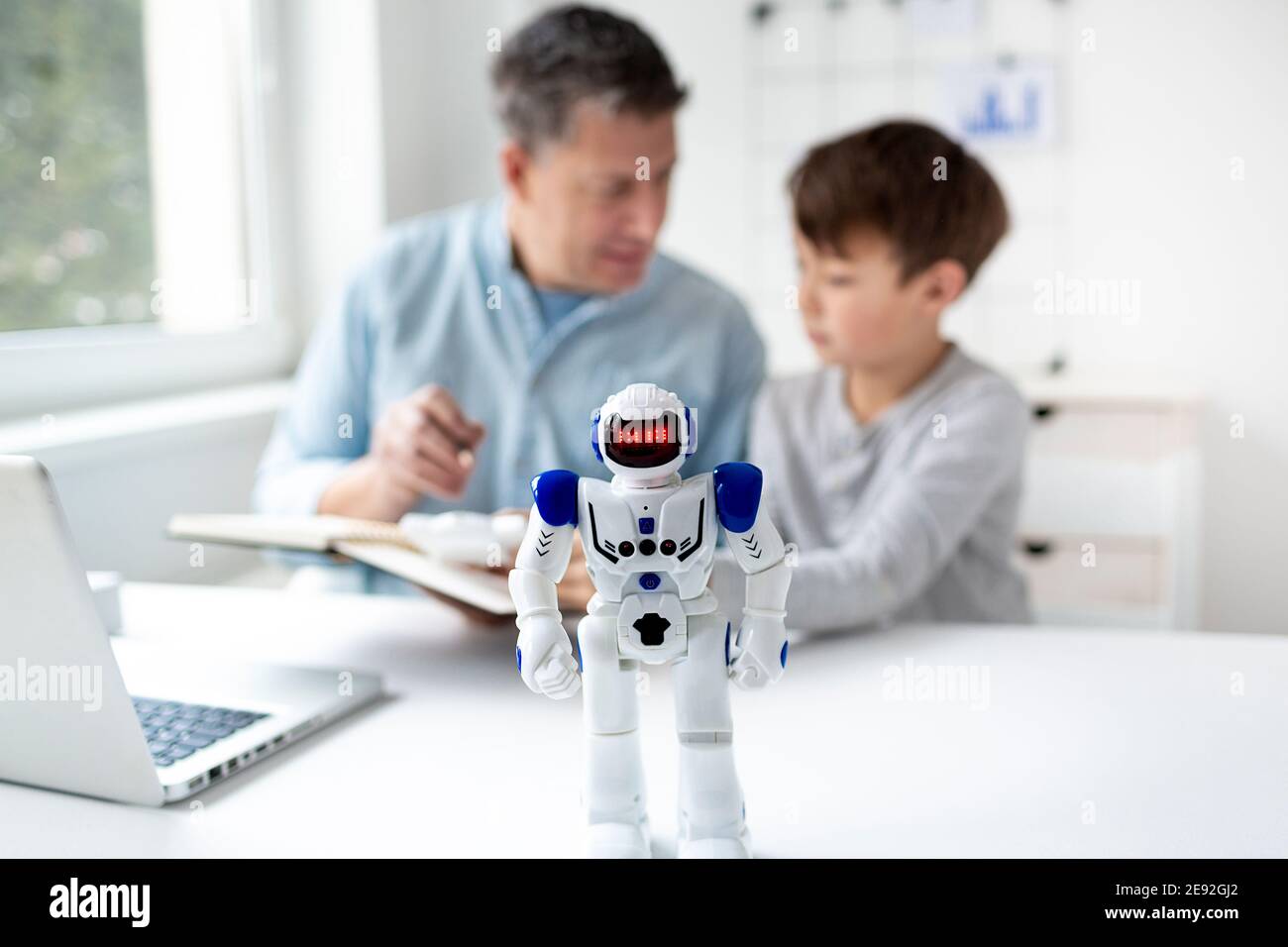 Dad and son working and playing with a robot Stock Photo - Alamy