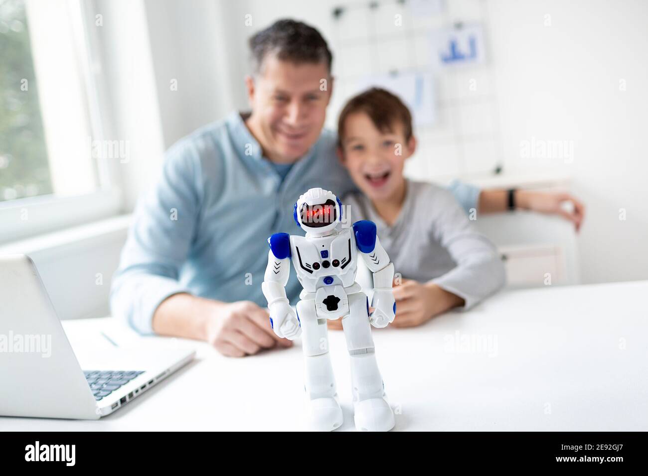 Dad and son working and playing with a robot Stock Photo - Alamy