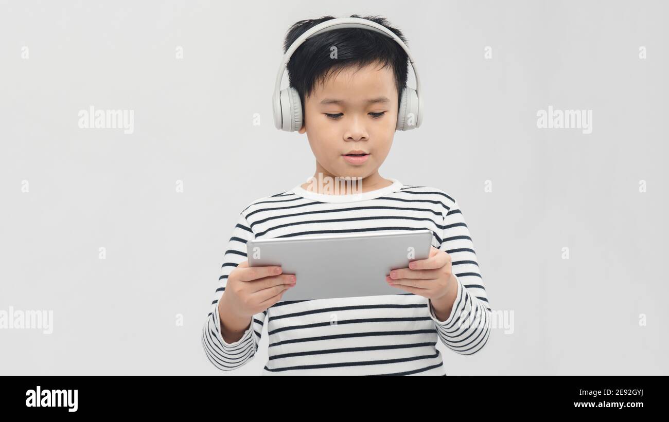 Child Boy listening to music or watching movie with headphones and ...