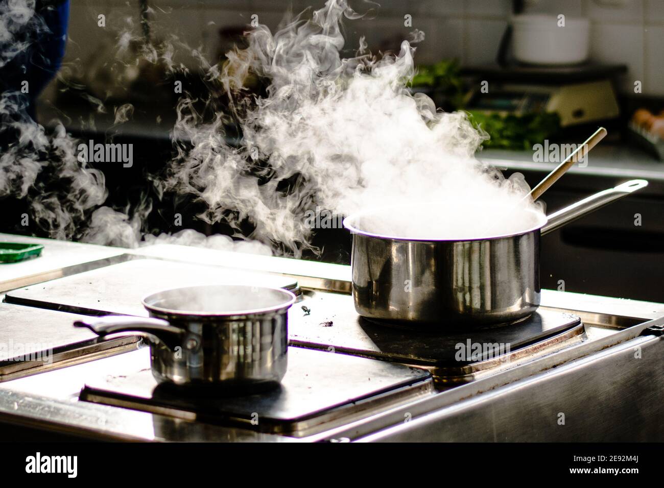 Chef cooking soup and water evaporating from a pot at a restaurant ...