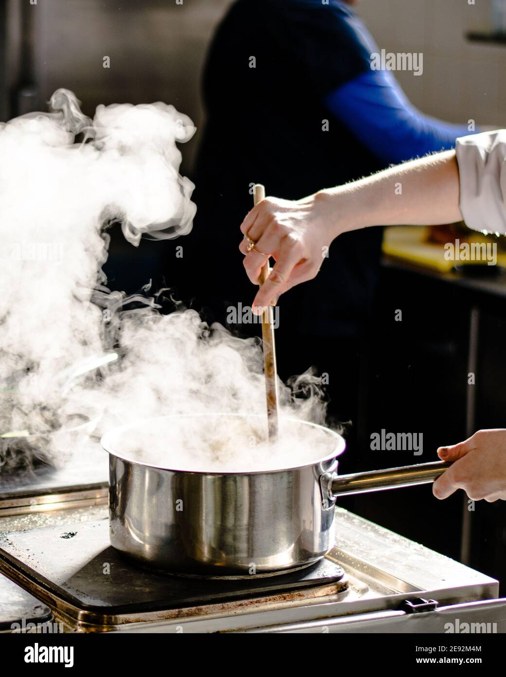 Chef cooking soup and water evaporating from a pot at a restaurant ...