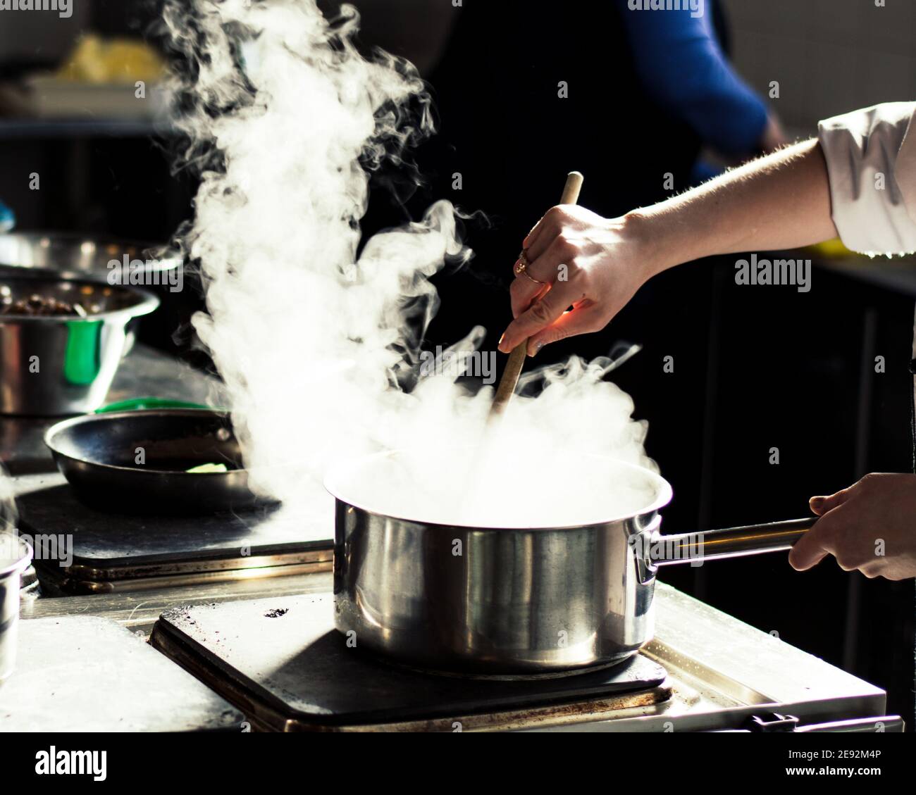 Chef cooking soup and water evaporating from a pot at a restaurant ...