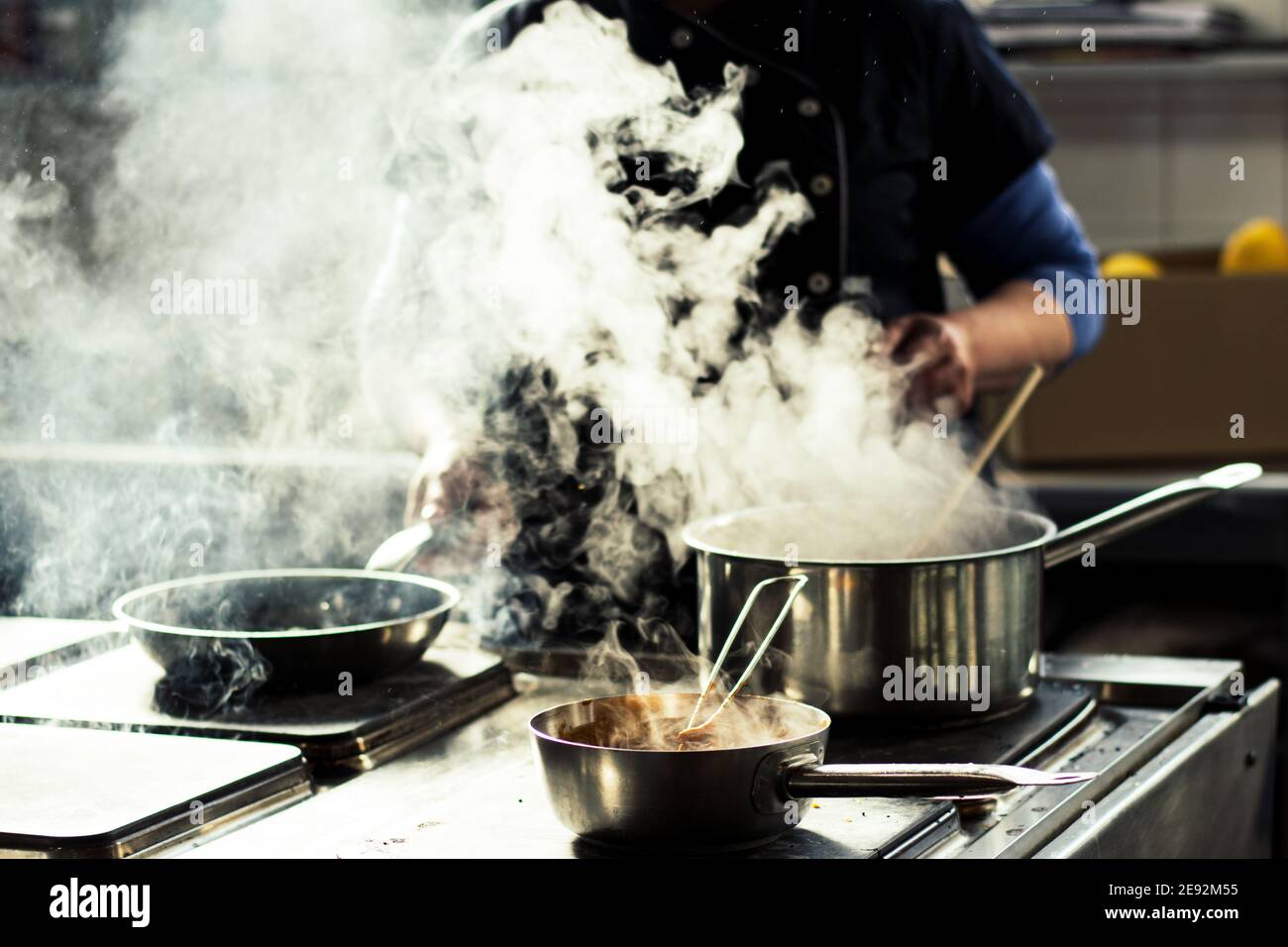 Chef cooking soup and water evaporating from a pot at a restaurant ...