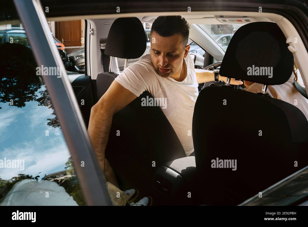 Mature man looking backwards while sitting in electric car Stock Photo ...