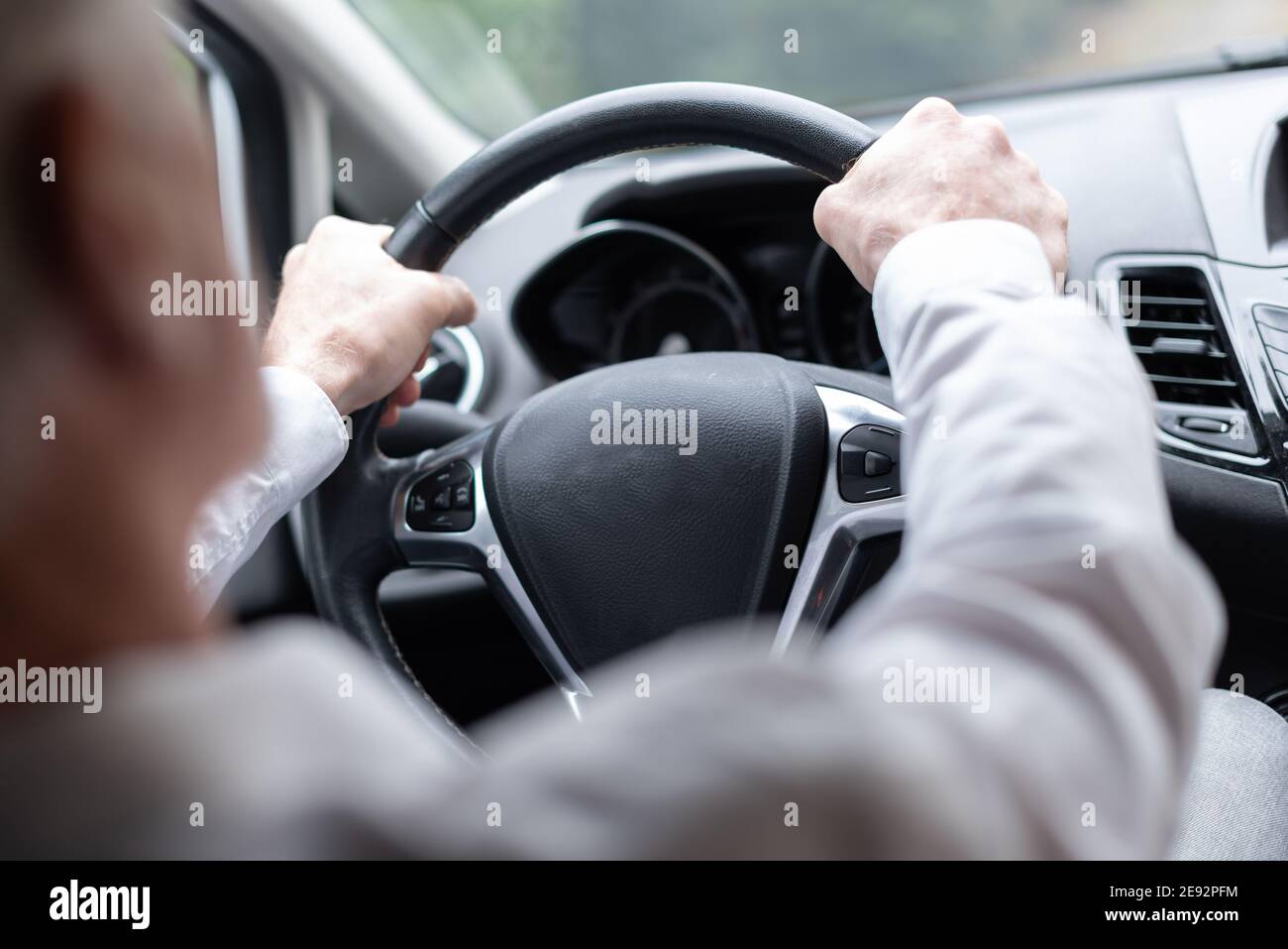 Man driving with his two hands on steering wheel Stock Photo - Alamy