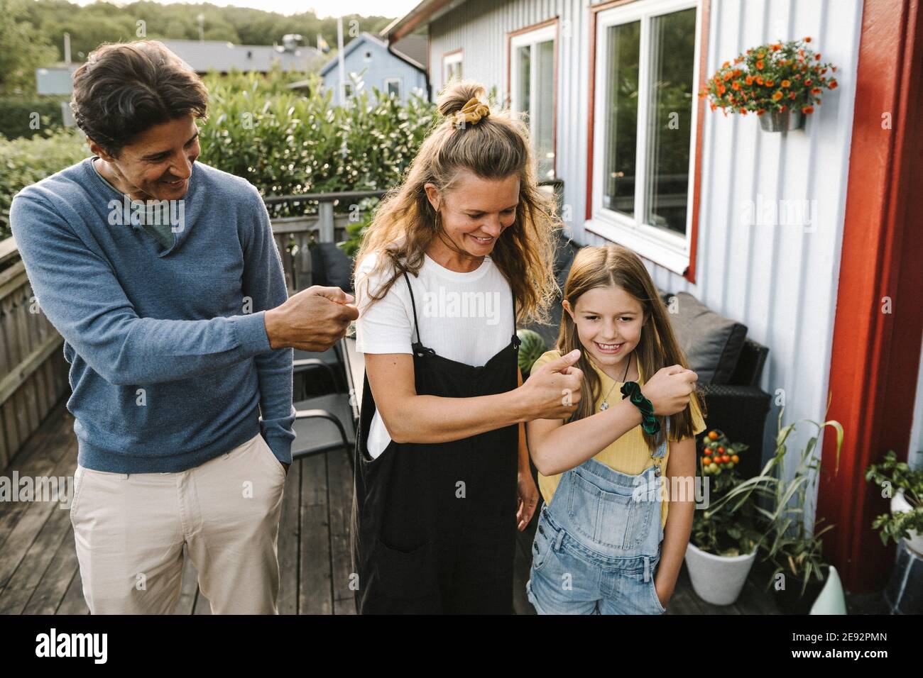 Smiling family doing hand gesture in balcony of house Stock Photo - Alamy