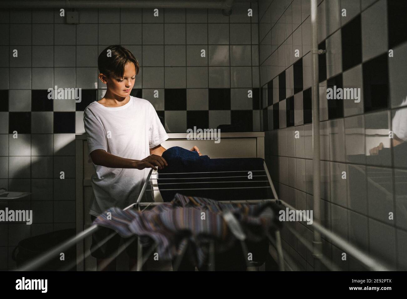 Boy doing laundry in utility room Stock Photo - Alamy