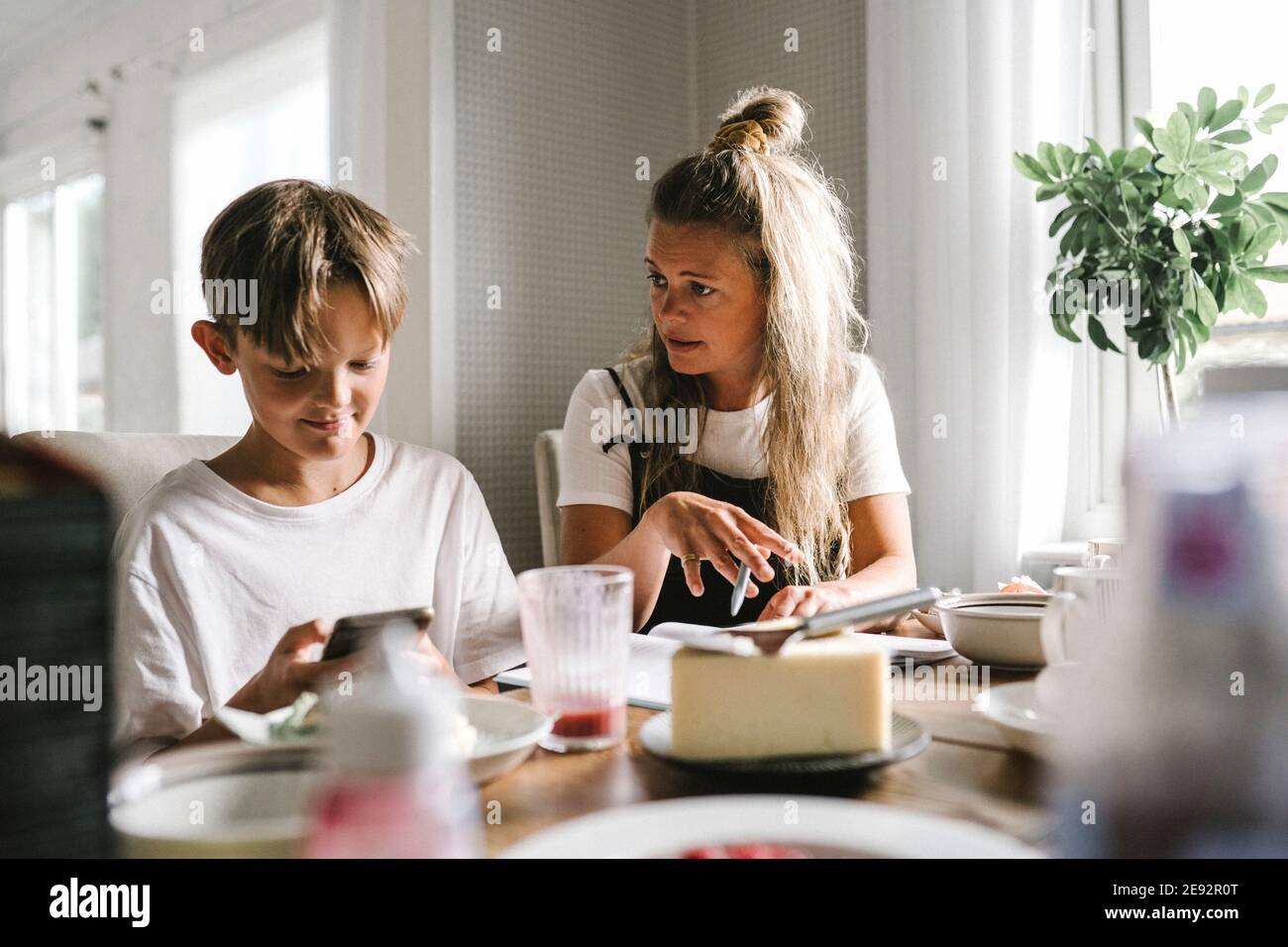 Using phone while eating family hi-res stock photography and images - Alamy