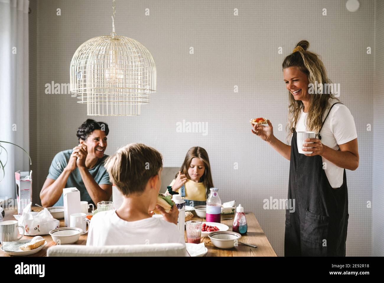 Smiling family having breakfast at dining table Stock Photo - Alamy