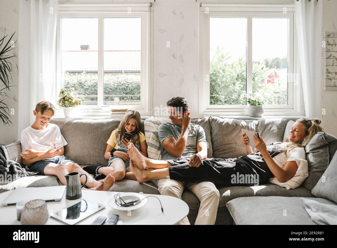 Happy family sitting on sofa hi-res stock photography and images - Alamy