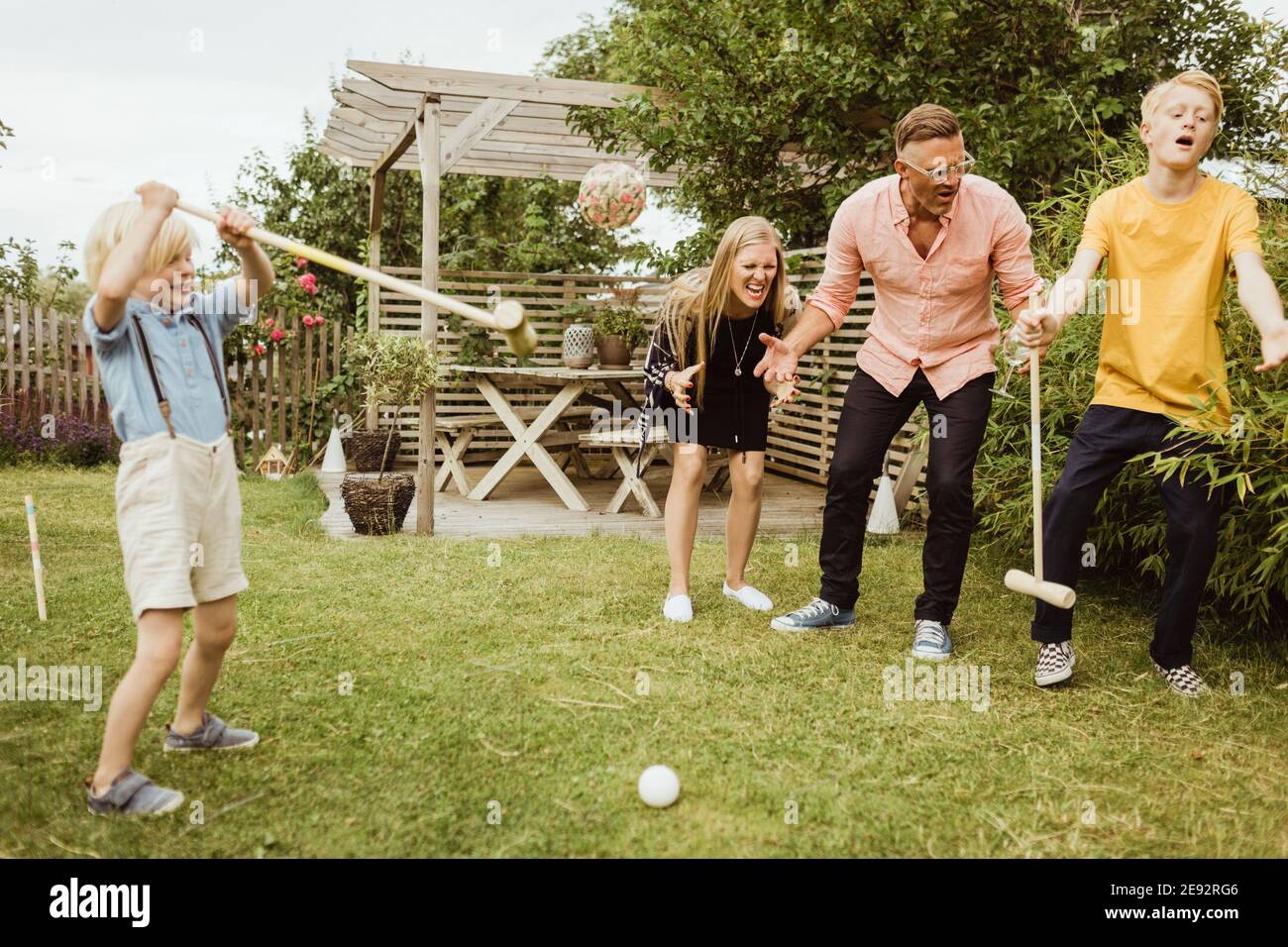 Cheerful family playing polo in front yard Stock Photo - Alamy