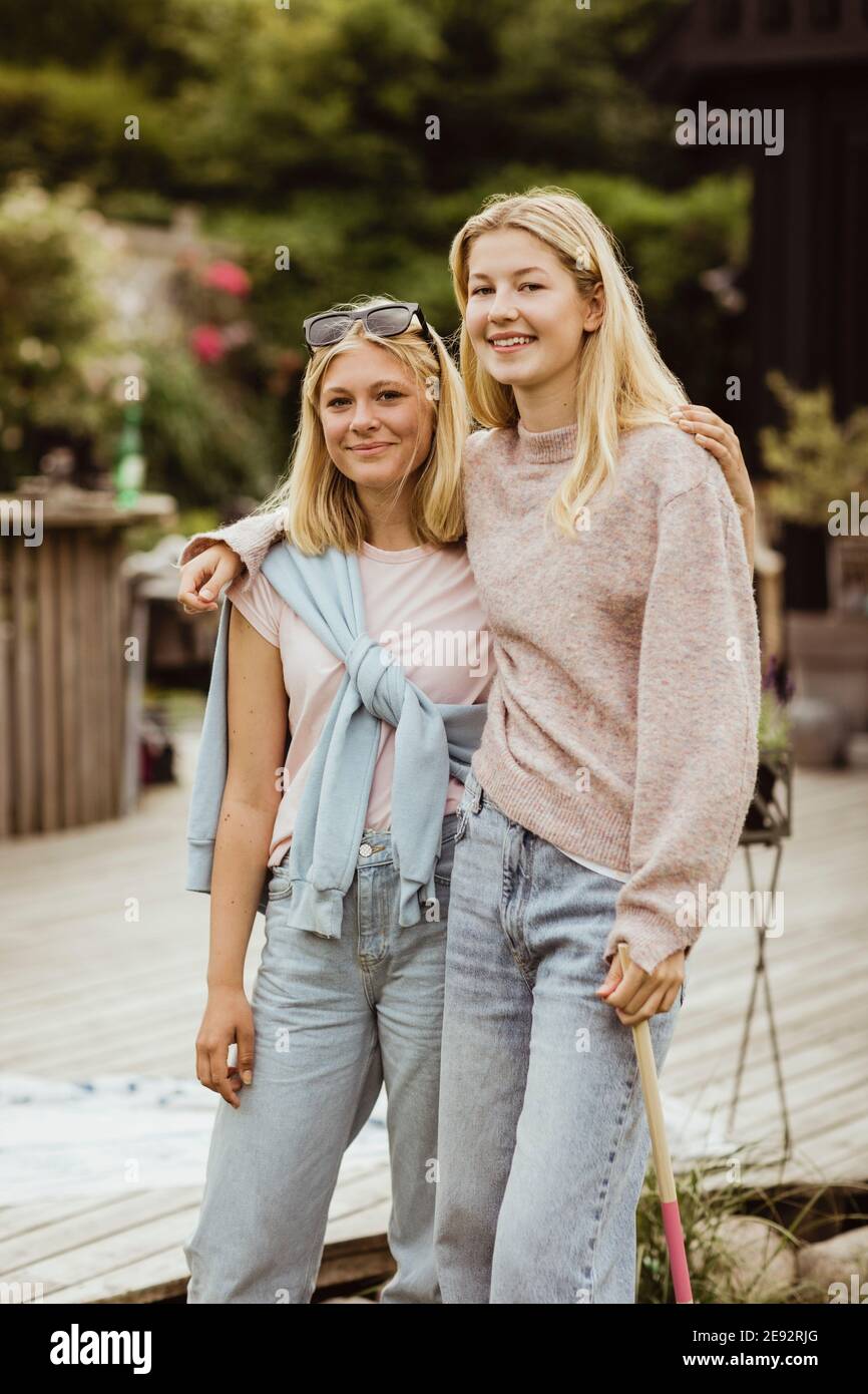 Two girls friends smiling arms hi-res stock photography and images - Alamy