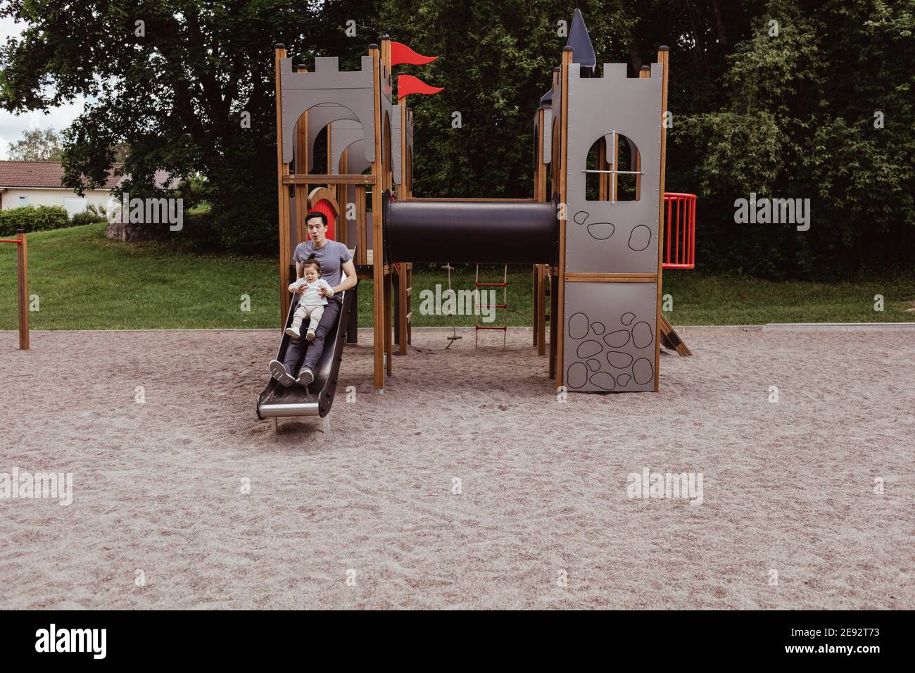 Father and baby son playing on slide at playground Stock Photo - Alamy