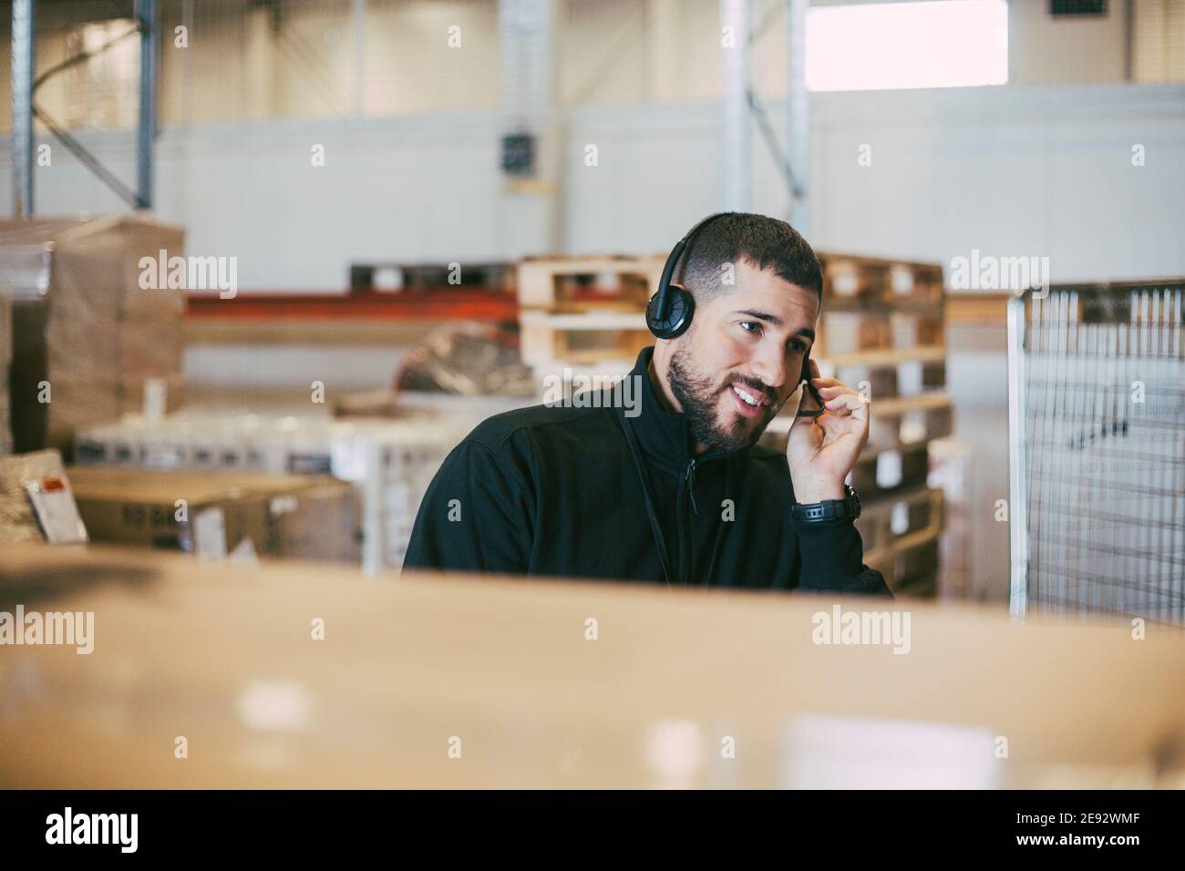 Male manual worker talking through headset at logistics warehouse Stock ...