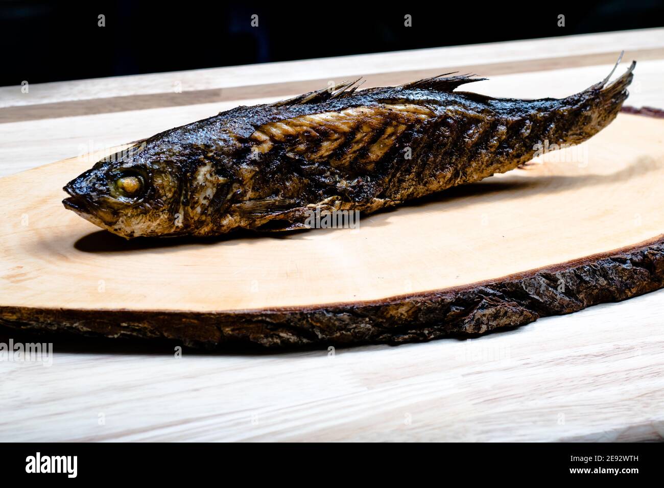 Fried fish on a wood plate at a restaurant Stock Photo - Alamy