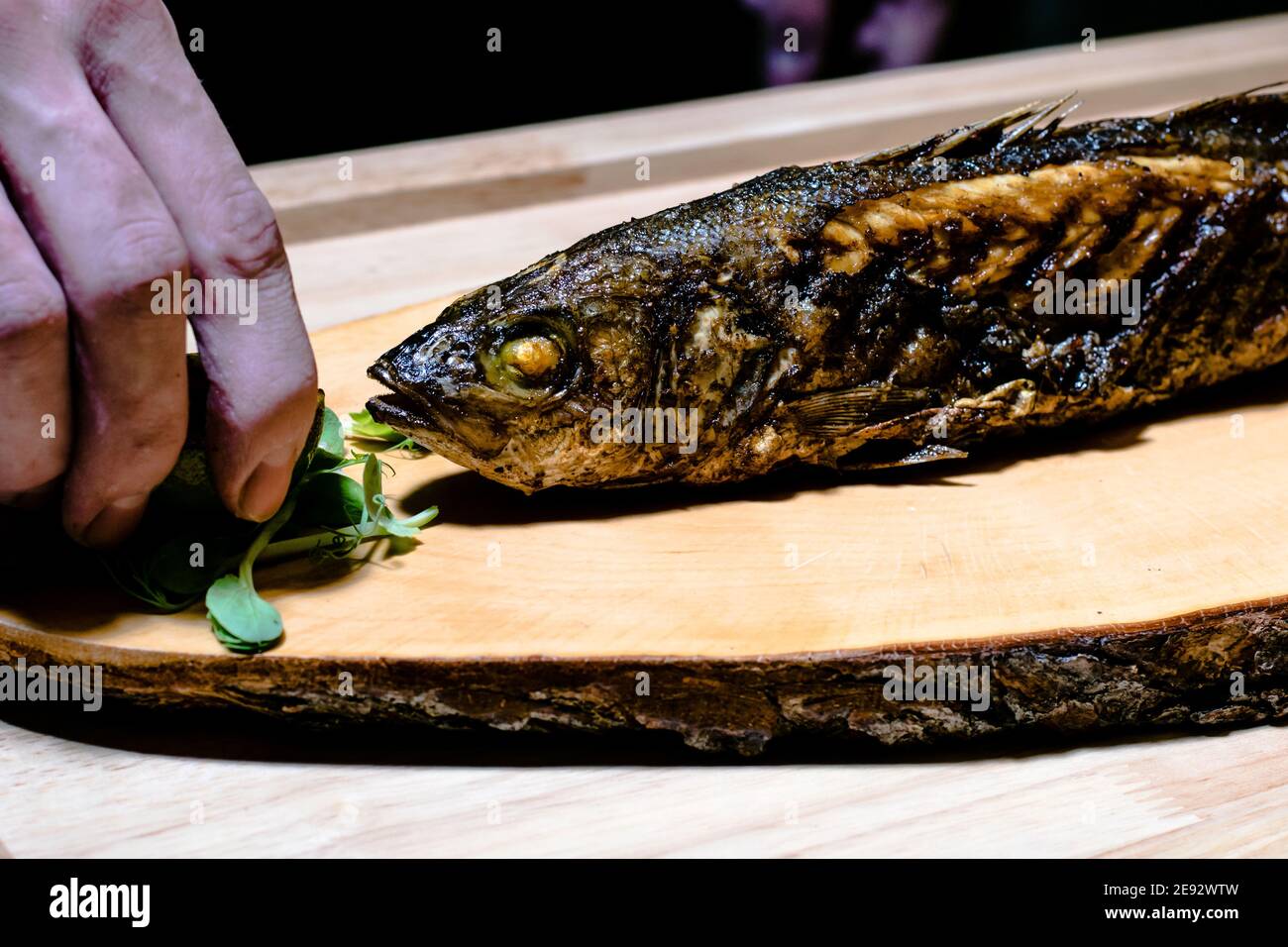 Fried fish on a wood plate at a restaurant Stock Photo - Alamy
