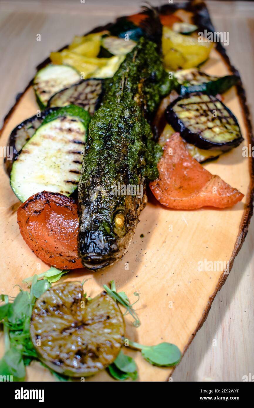 Fried fish on a wood plate at a restaurant Stock Photo - Alamy