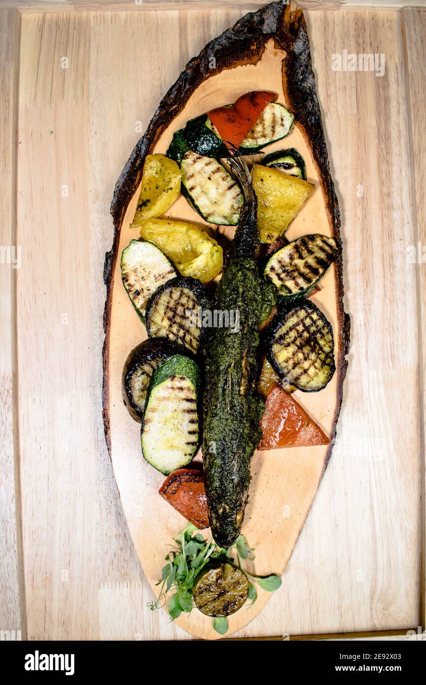 Fried fish on a wood plate at a restaurant Stock Photo - Alamy