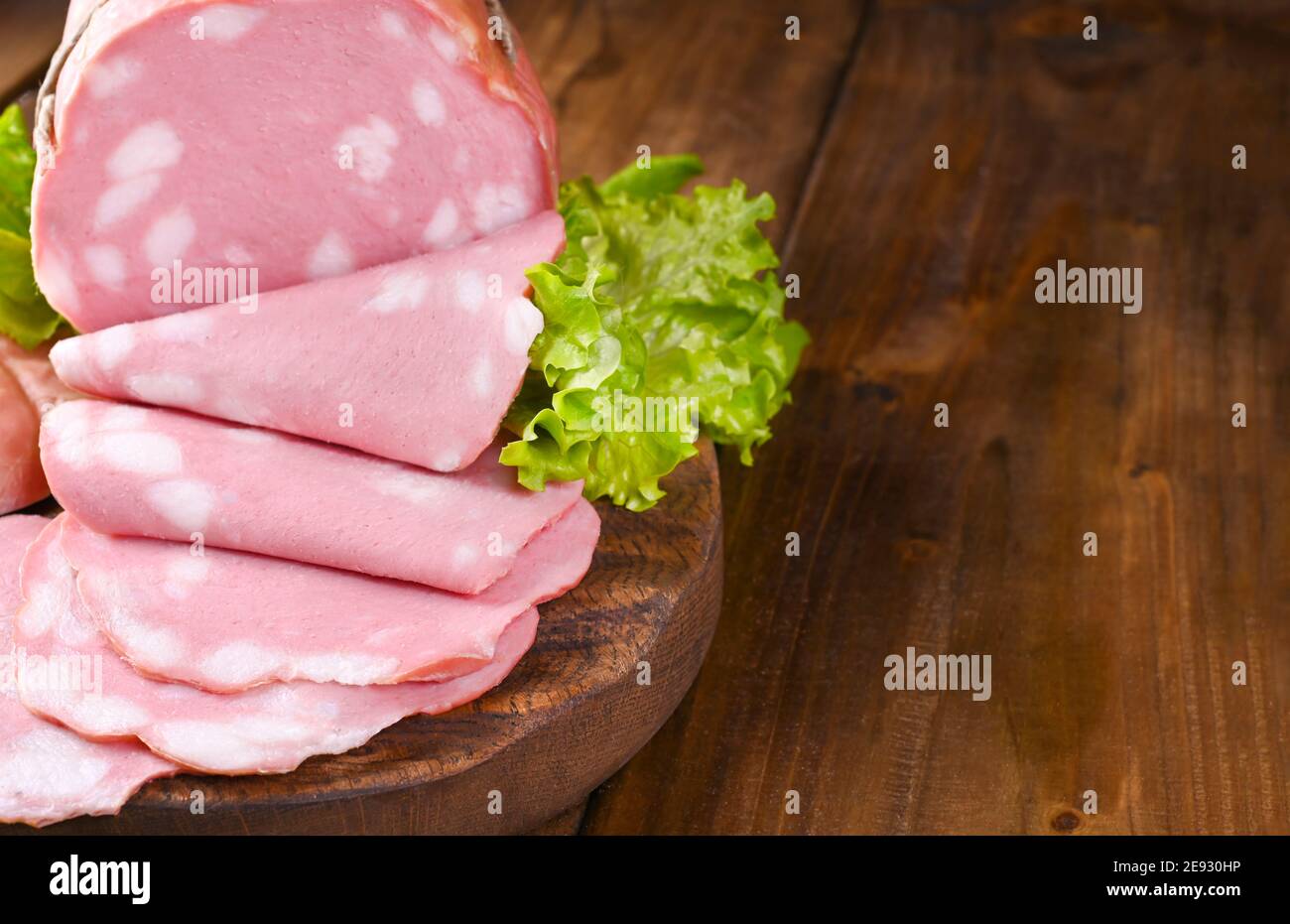 Italian Whole block of mortadella on a wooden plate decorated with ...