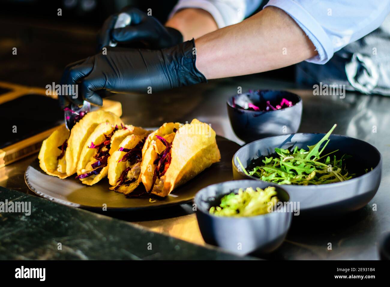A chef plating tacos in a restaurant kitchen Stock Photo - Alamy