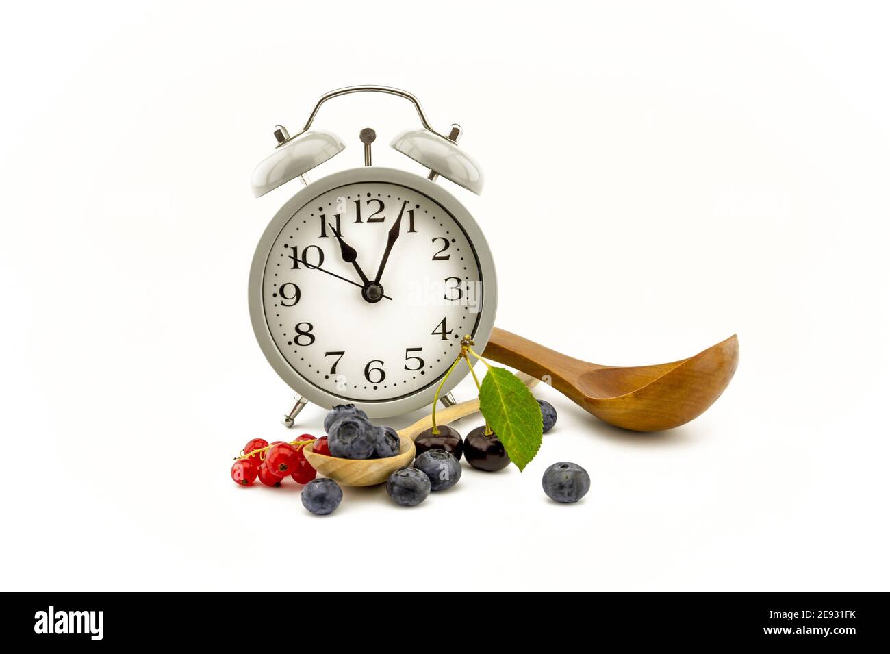 Culinary still life with old-fashioned alarm clock, wooden spoon ...