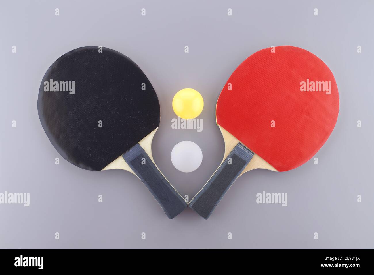 Red and black table tennis racks with a white and an yellow ping pong ...
