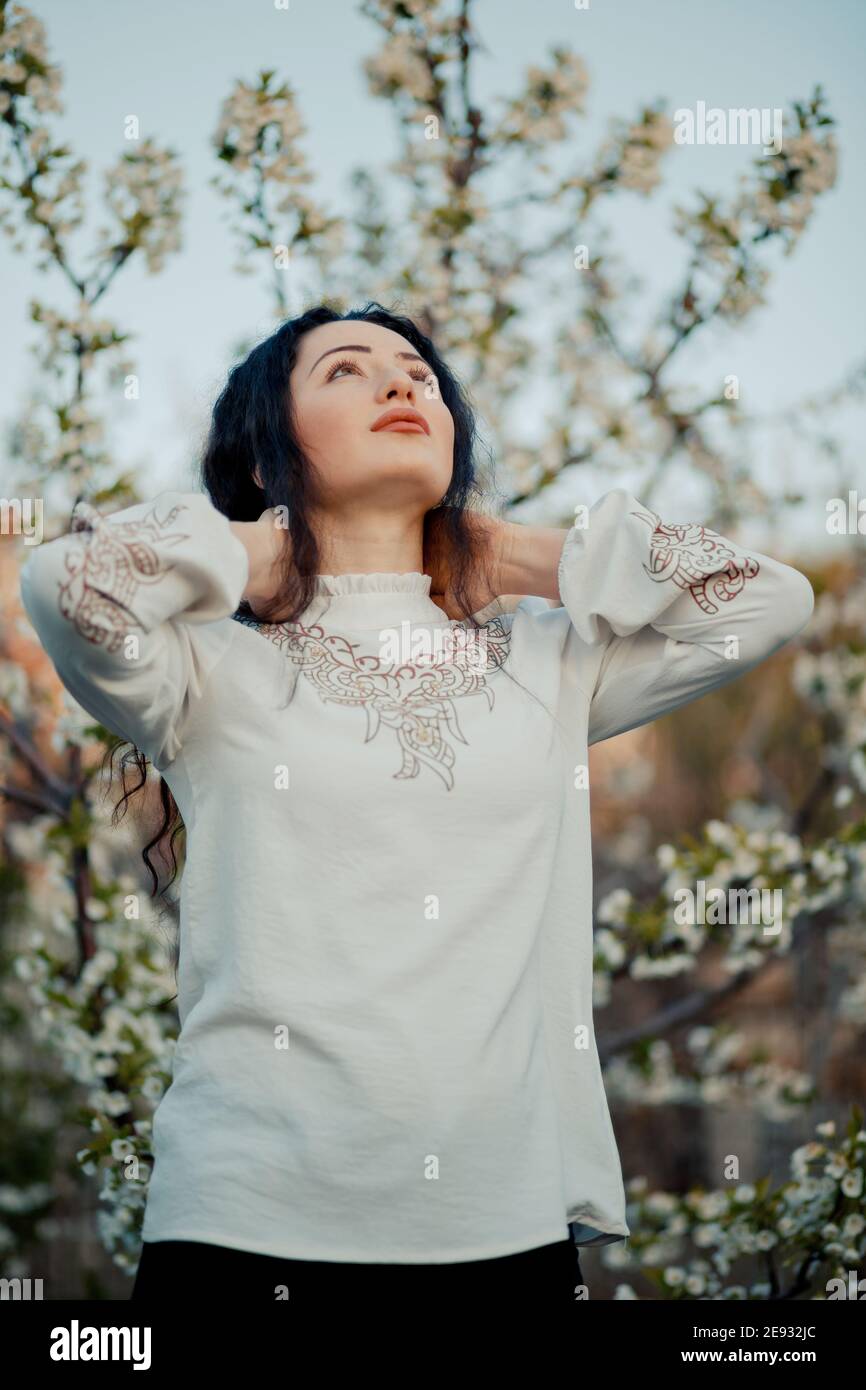 Nice looking girl holding from her neck and looking at the sky in ...