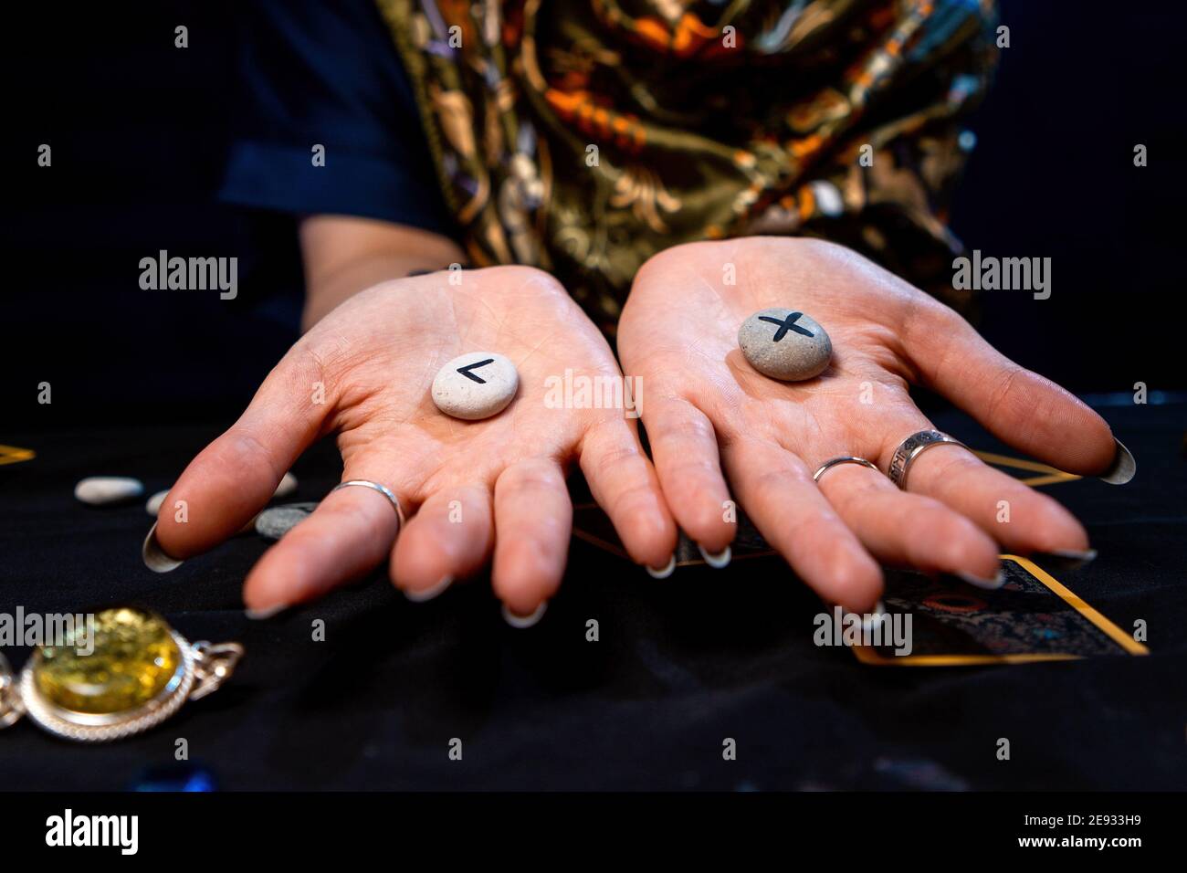 On the palms of the fortune teller are runes. Close up. The concept of ...