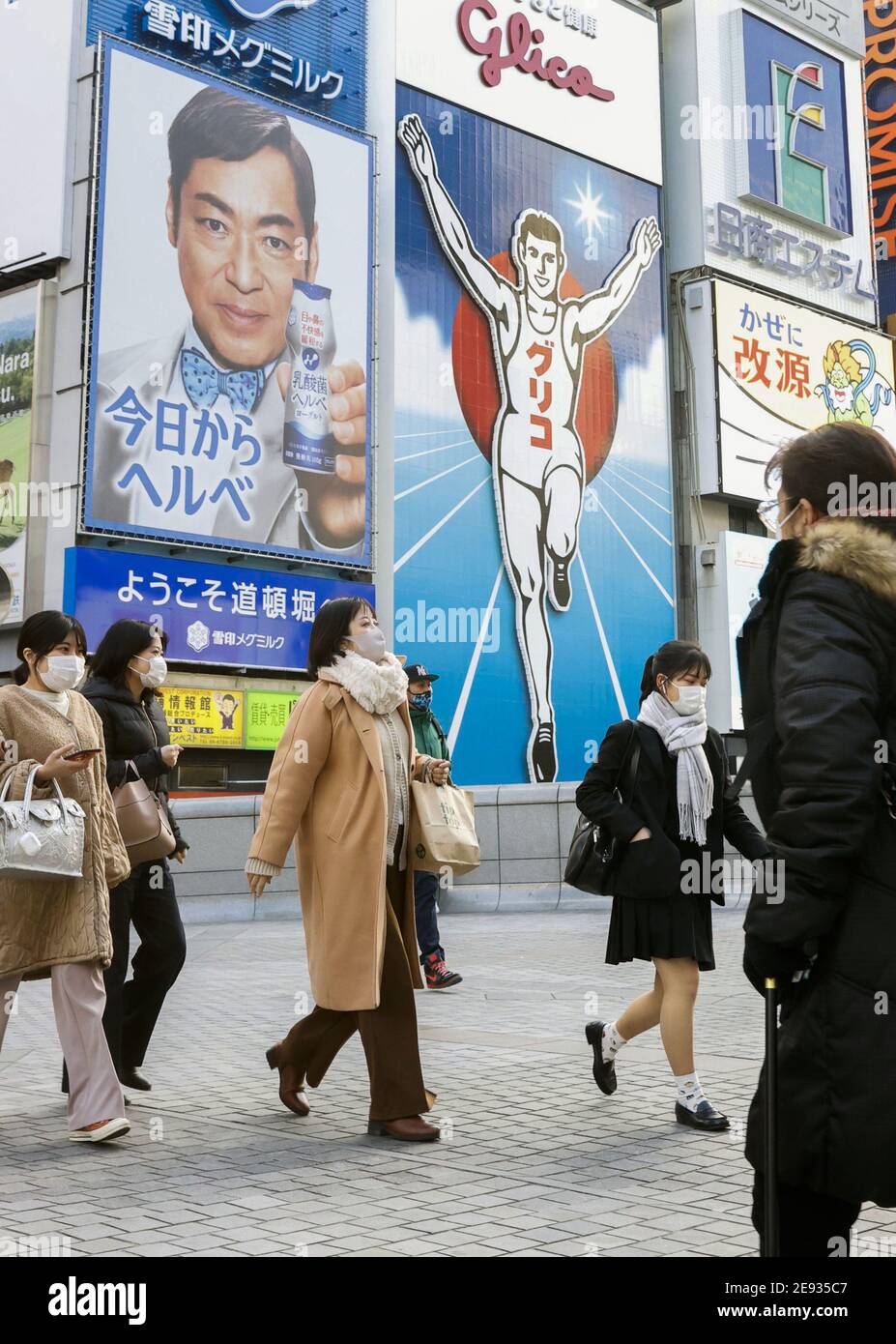 People wearing face masks walk in Osaka's Minami area on Feb. 2, 2021 ...