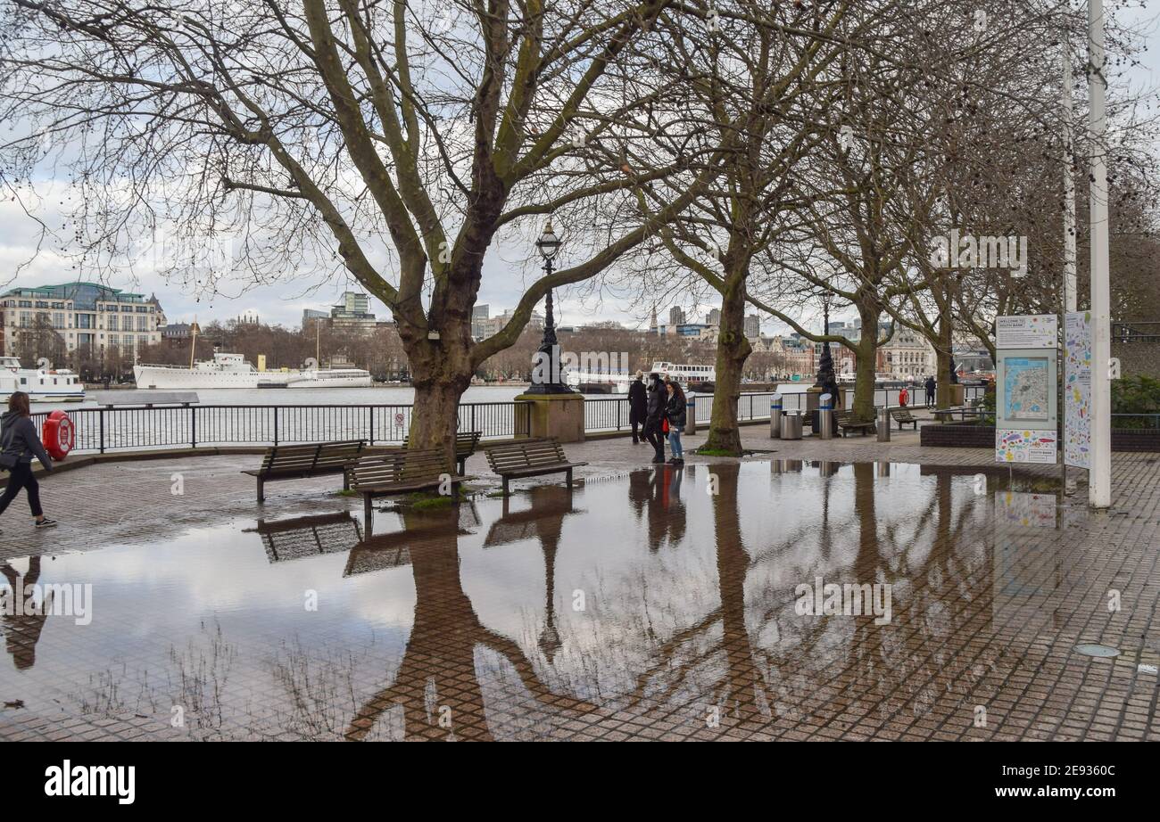 People walking along the Queen's Walk promenade, South Bank, in winter ...