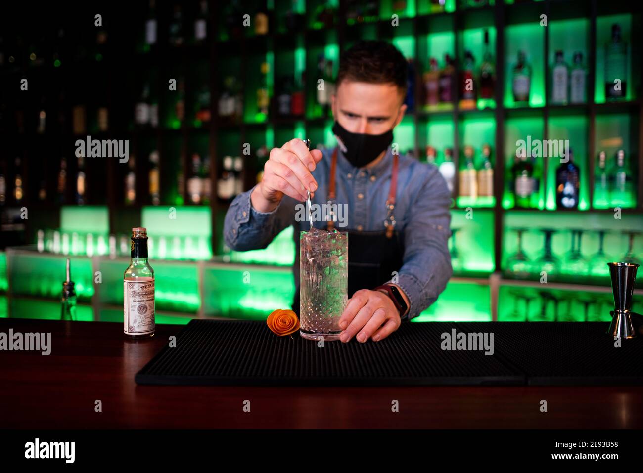 Young guy working as a bartender while preparing cocktails in a pub ...