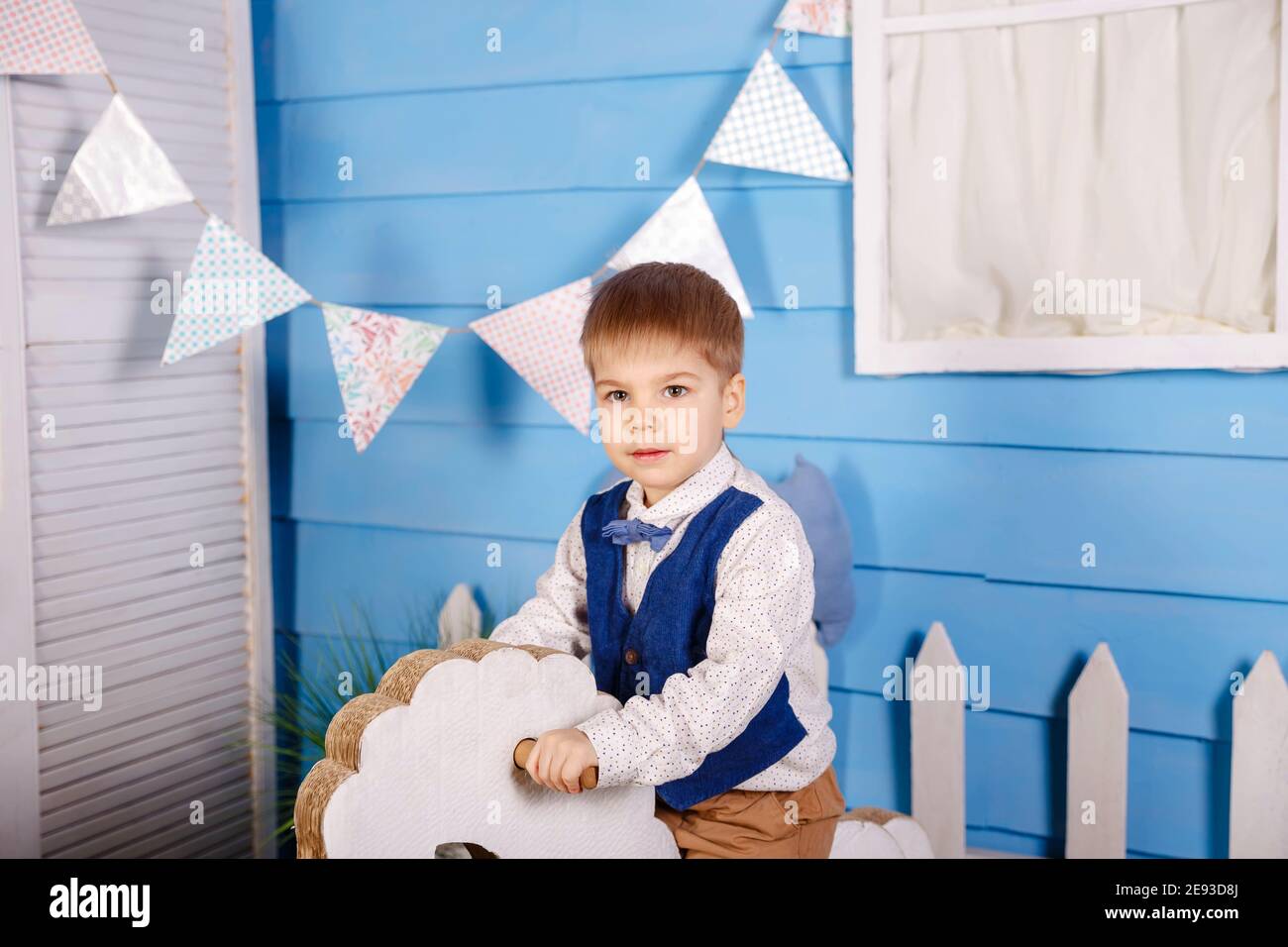 Surprised kid looking at camera on blue background. Birthday party ...