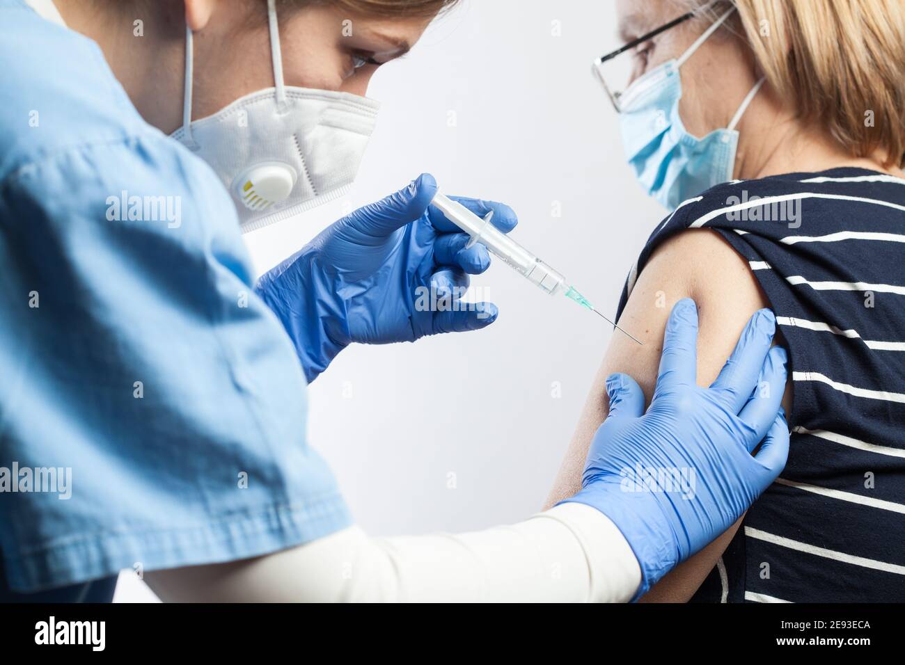Female medical worker giving injection shot to elderly woman,doctor or ...