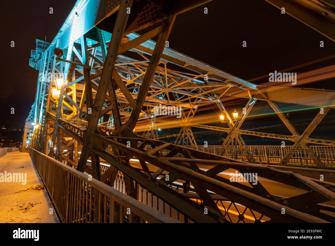 Closeup of a metal structure of a bridge captured at night illuminated ...
