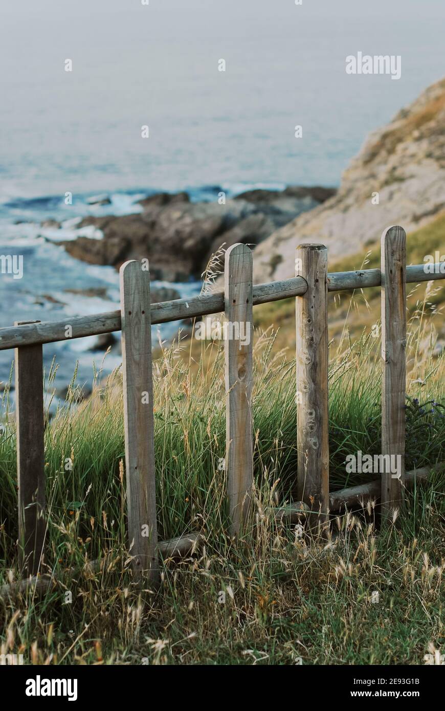 Wooden railing and nature with views of the wavy sea and rocks Stock ...