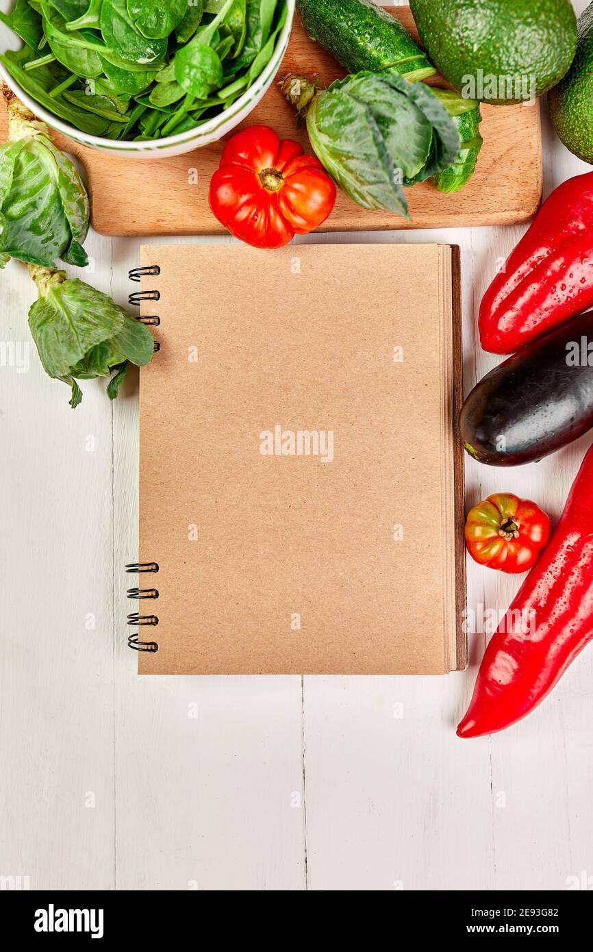Flat lay of assorted vegetables around cooking recipe book, grocering ...