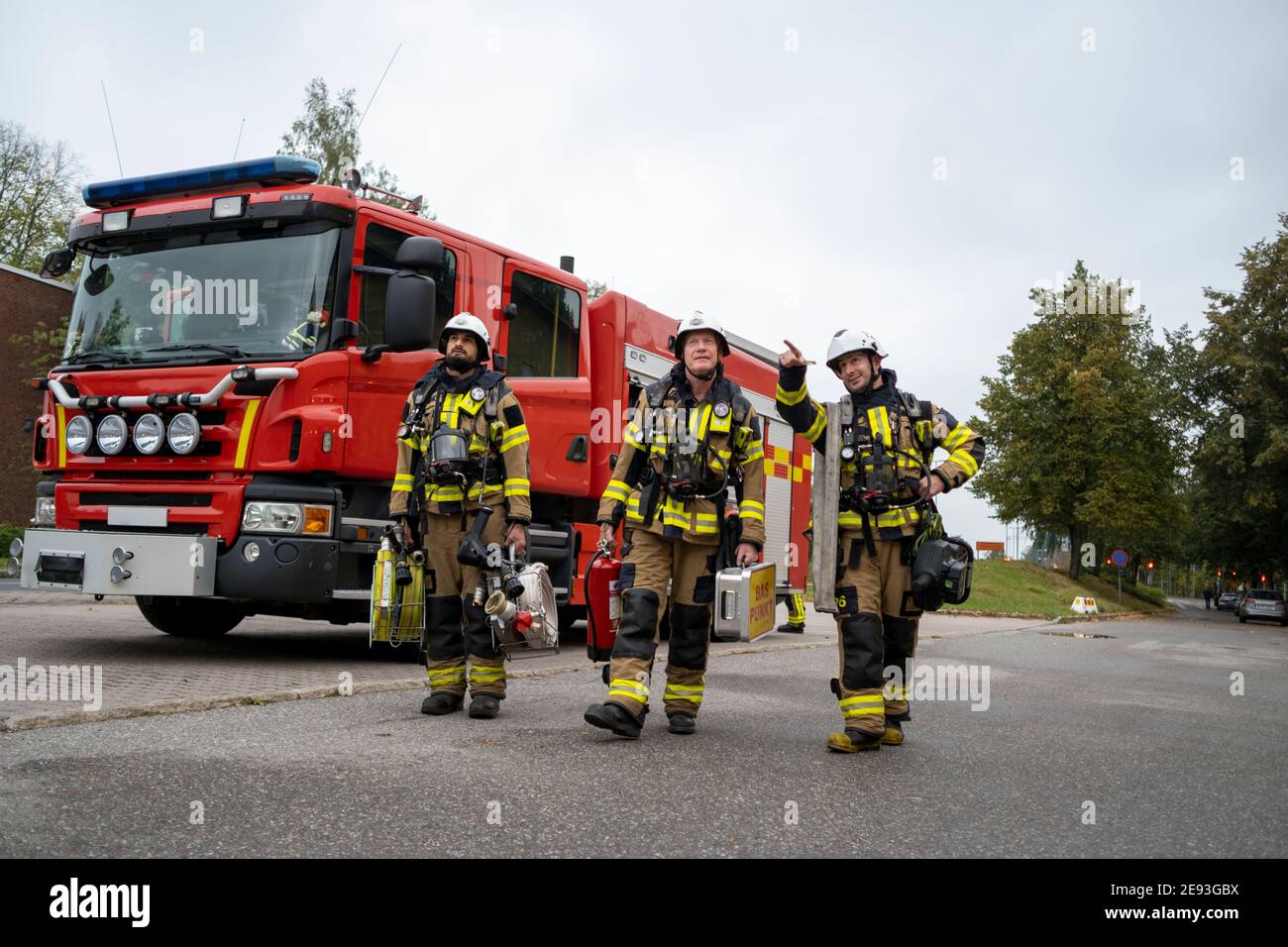 Firefighters walking, fire engine in background Stock Photo - Alamy