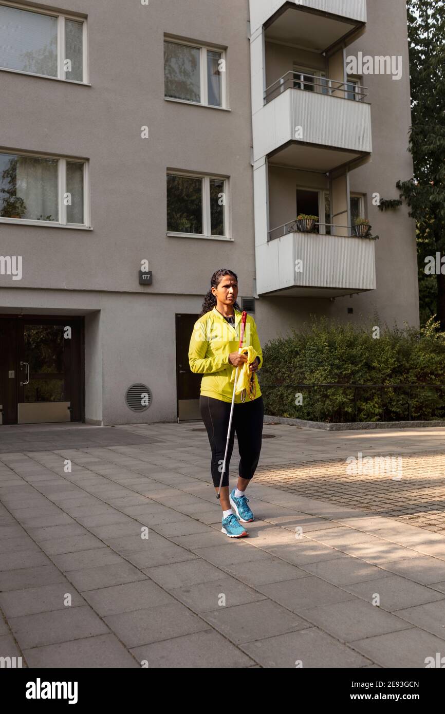 Visually impaired woman standing in front of block of flats Stock Photo ...