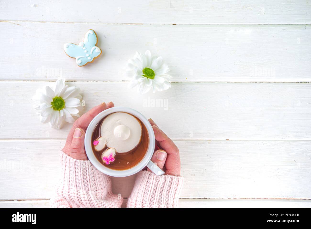 Easter hot chocolate with marshmallow bunny rabbits. Girl hands hold ...