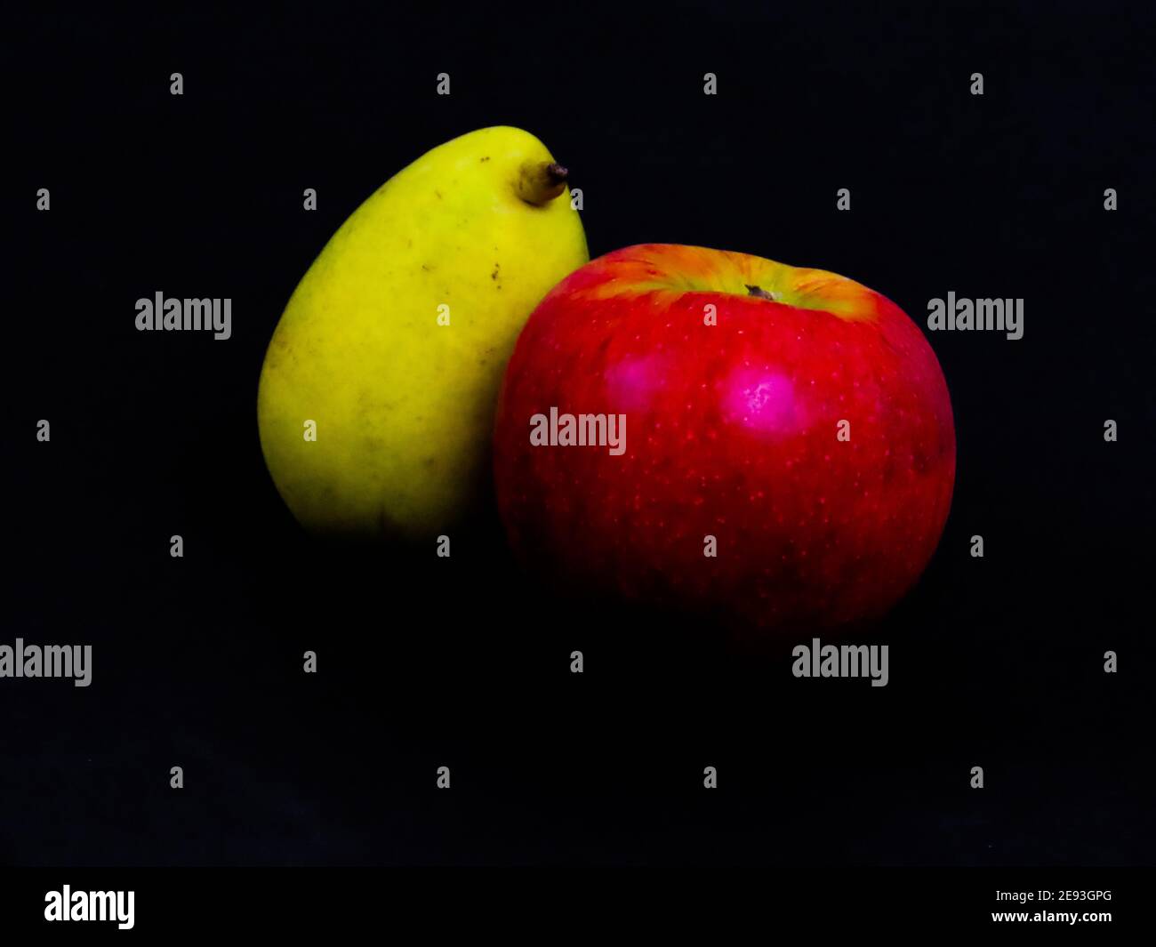 Red apple and mango isolated in the black background, the concept of GM ...