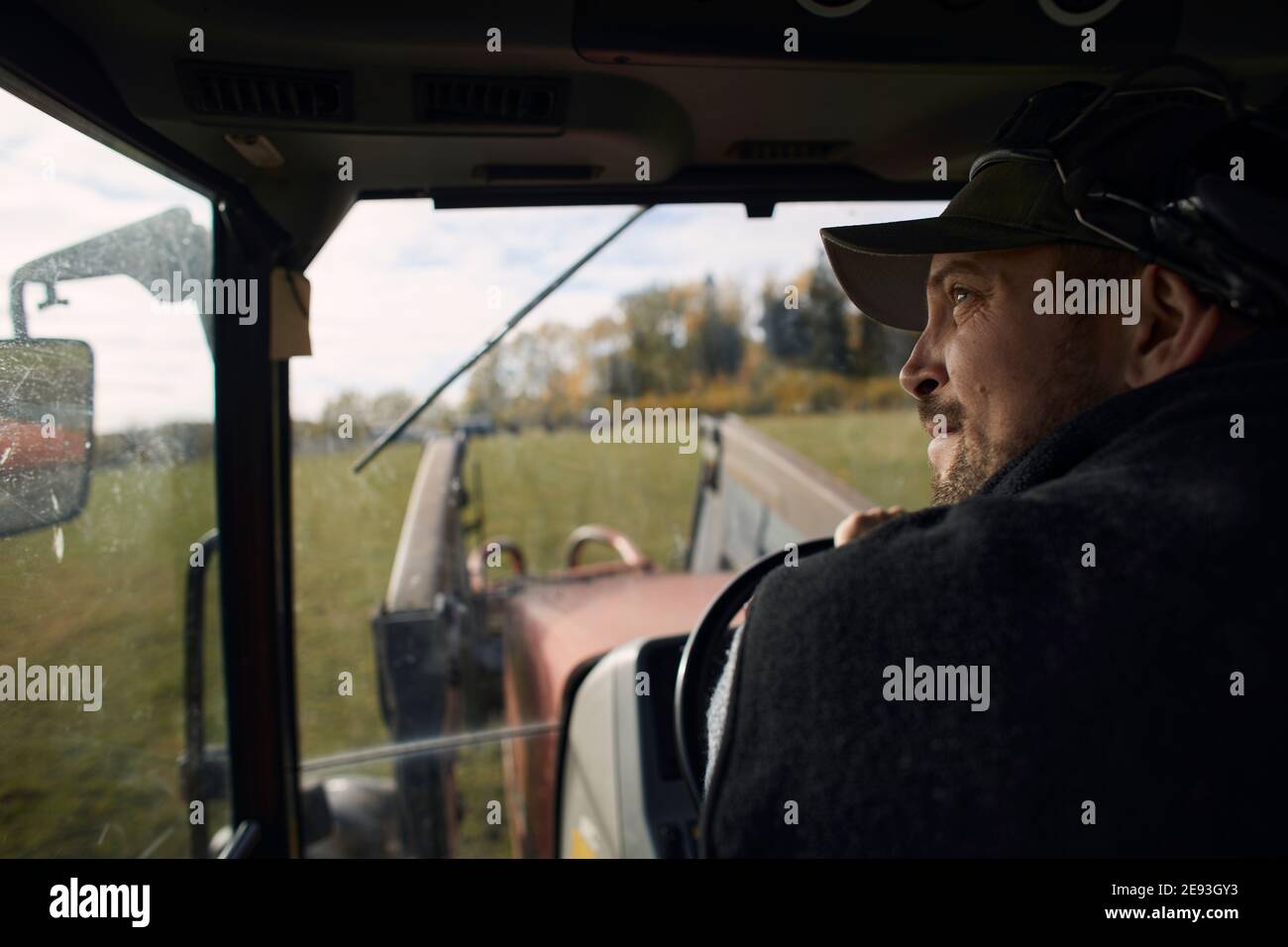 Farmer driving tractor Stock Photo - Alamy