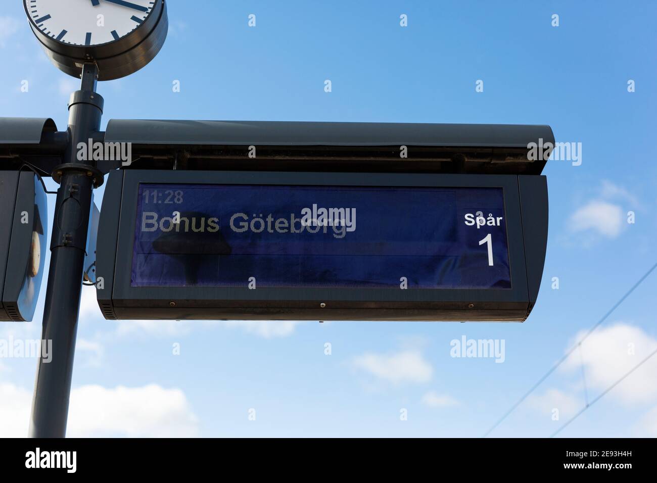 Clock and sign at train platform Stock Photo - Alamy