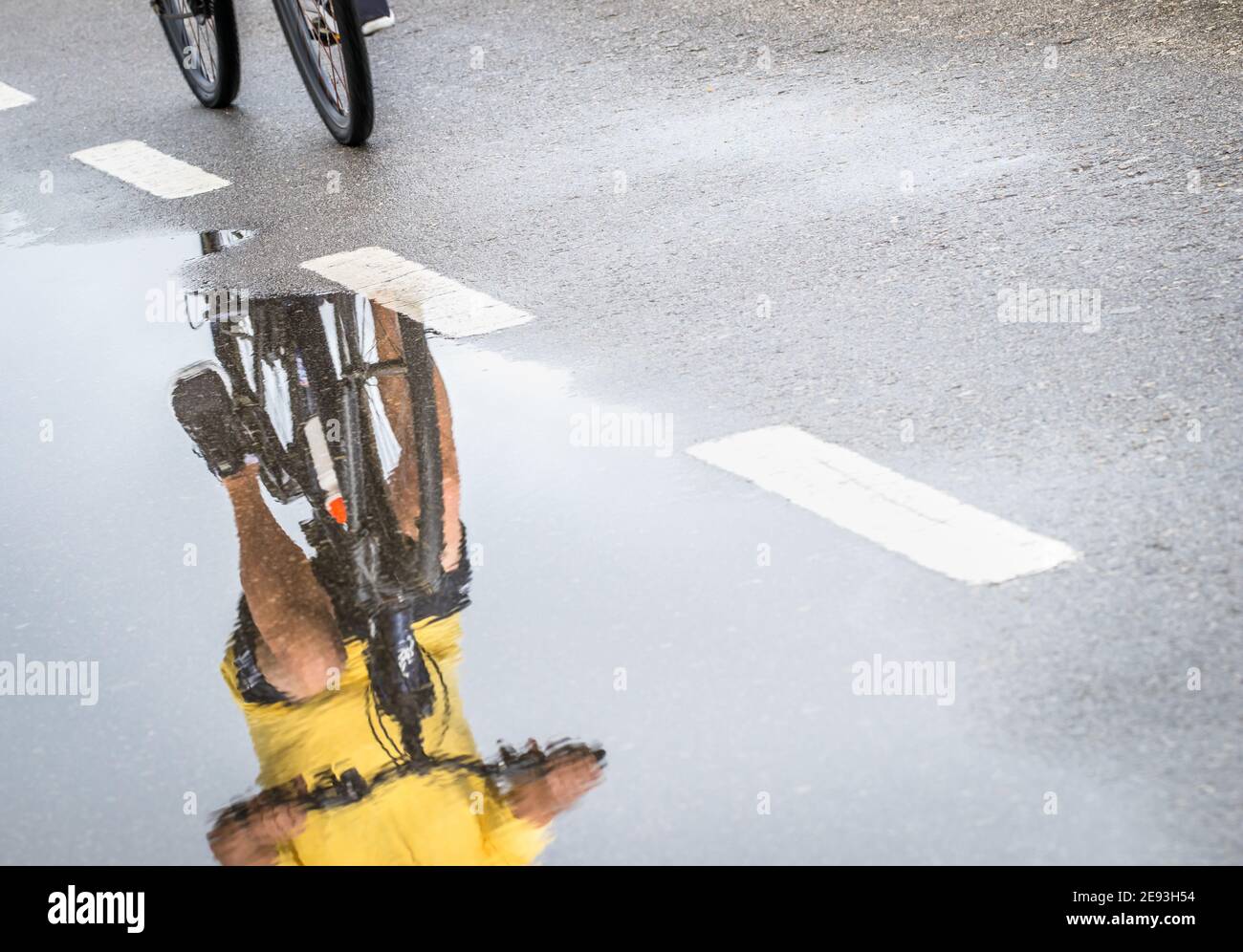 Reflection of a cyclist in the puddle of rainwater Stock Photo - Alamy