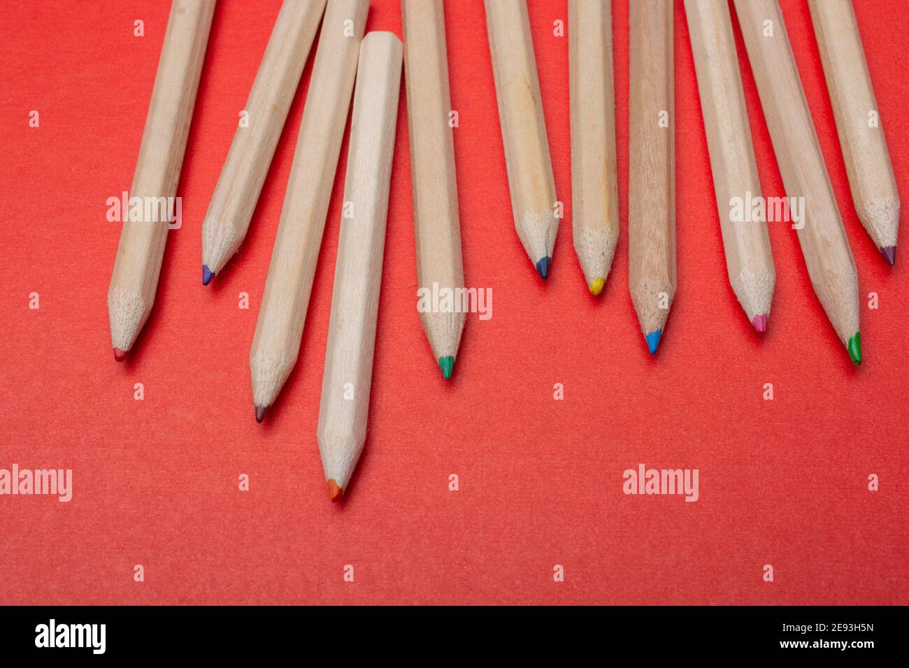 Colored pencils on red background. Many different colored pencils Stock ...