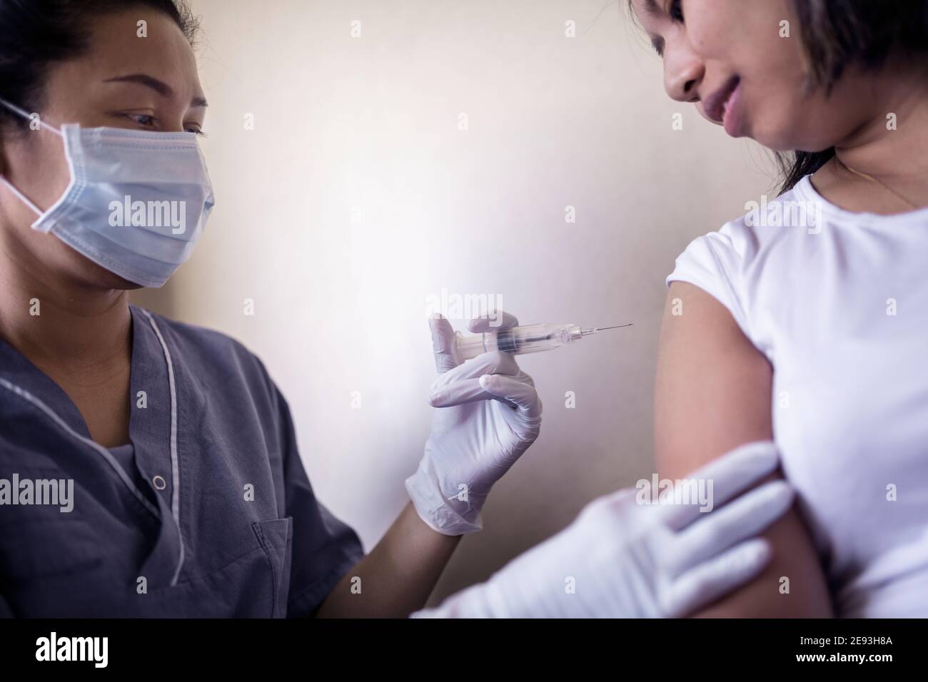 Woman receiving injection in her arm Stock Photo - Alamy