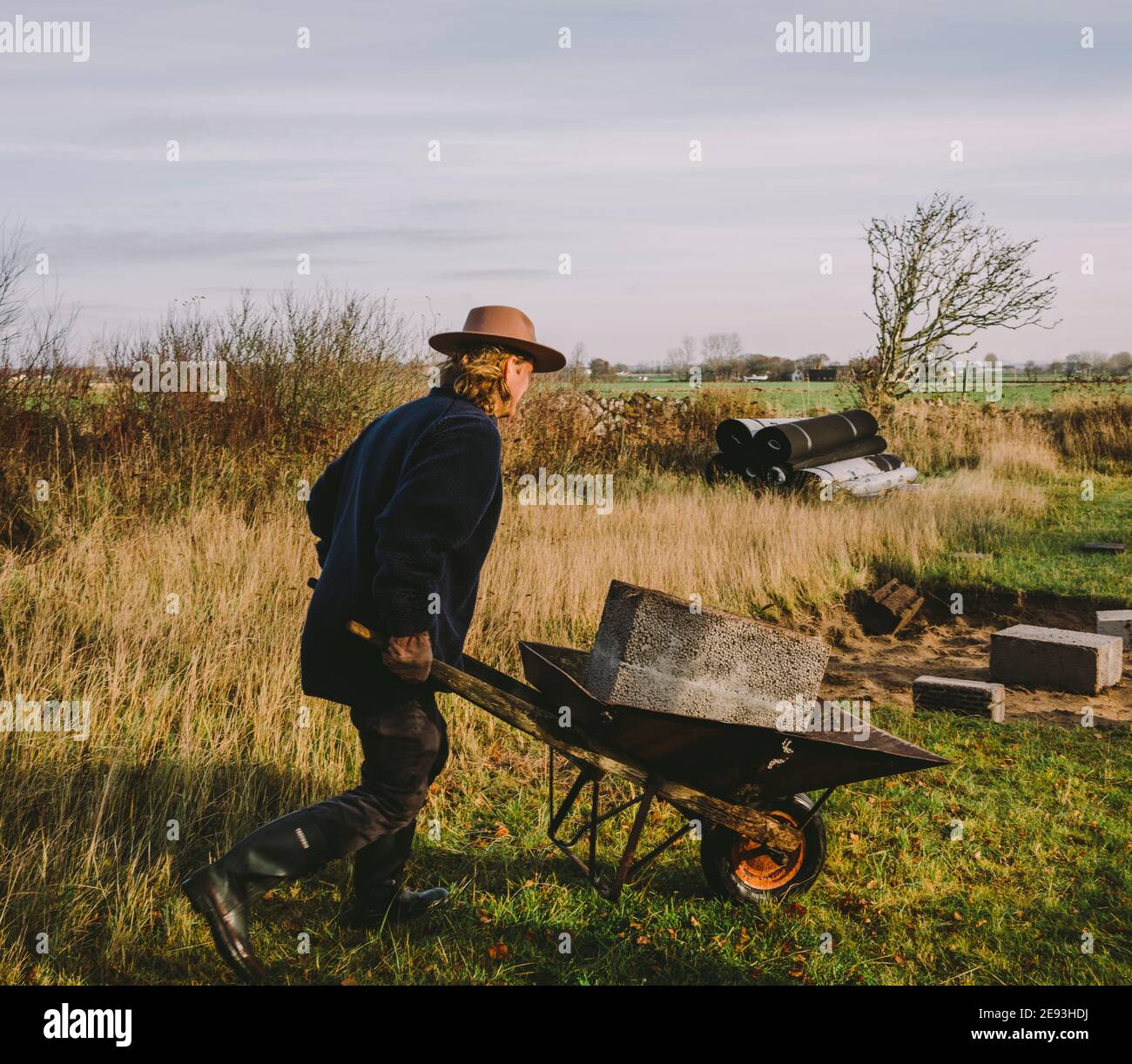 Man carrying bricks in wheelbarrow Stock Photo - Alamy