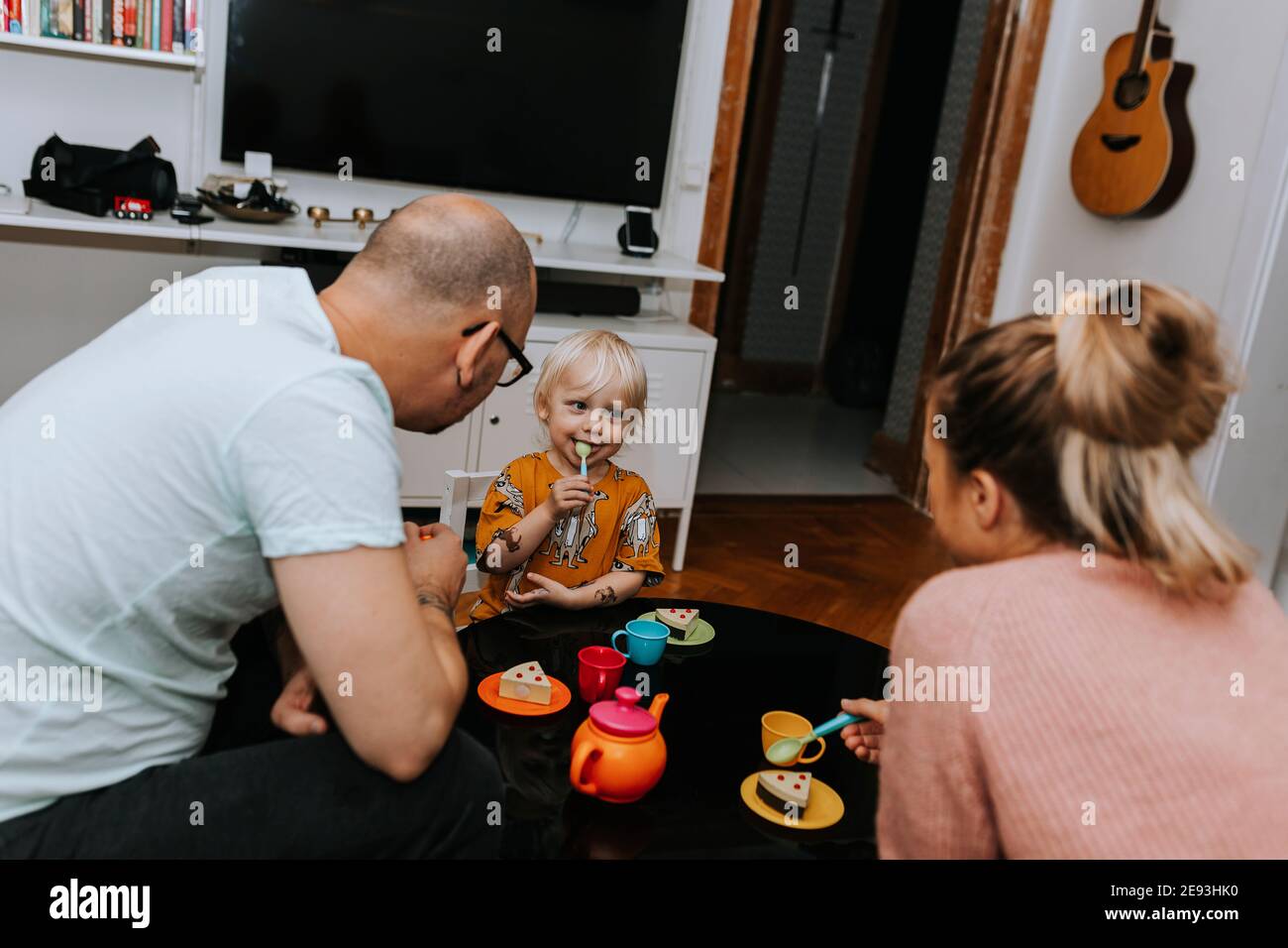 Parents with toddler having tea party Stock Photo - Alamy