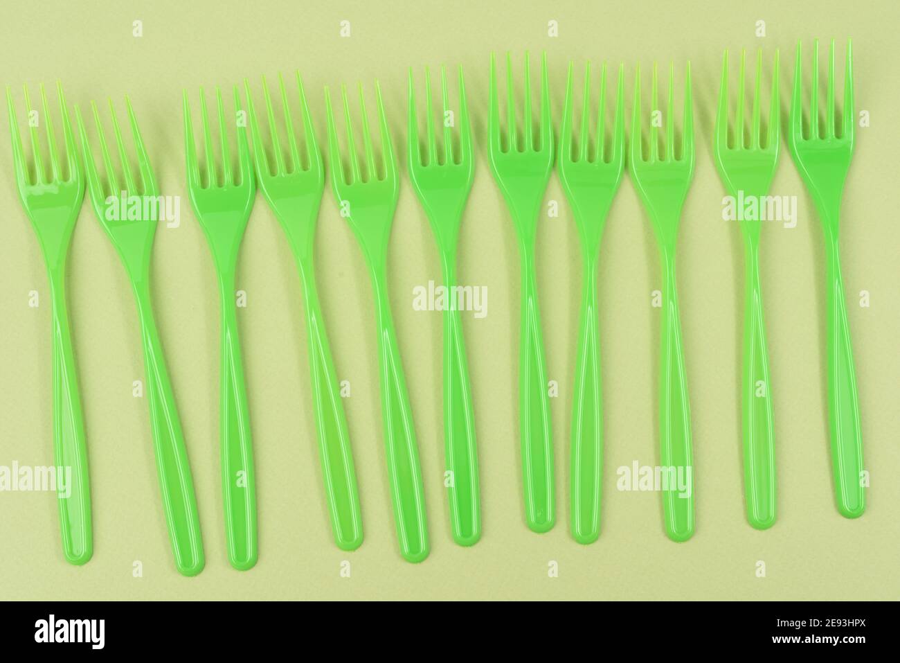 stack of green plastic forks on a green background, top view Stock ...