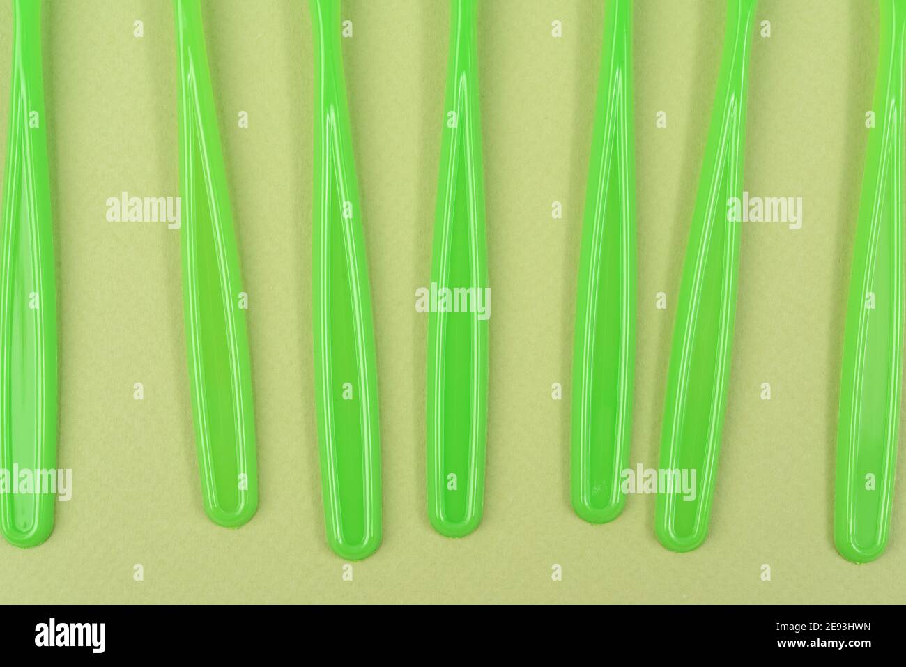 stack of green plastic forks on a green background, top view Stock ...