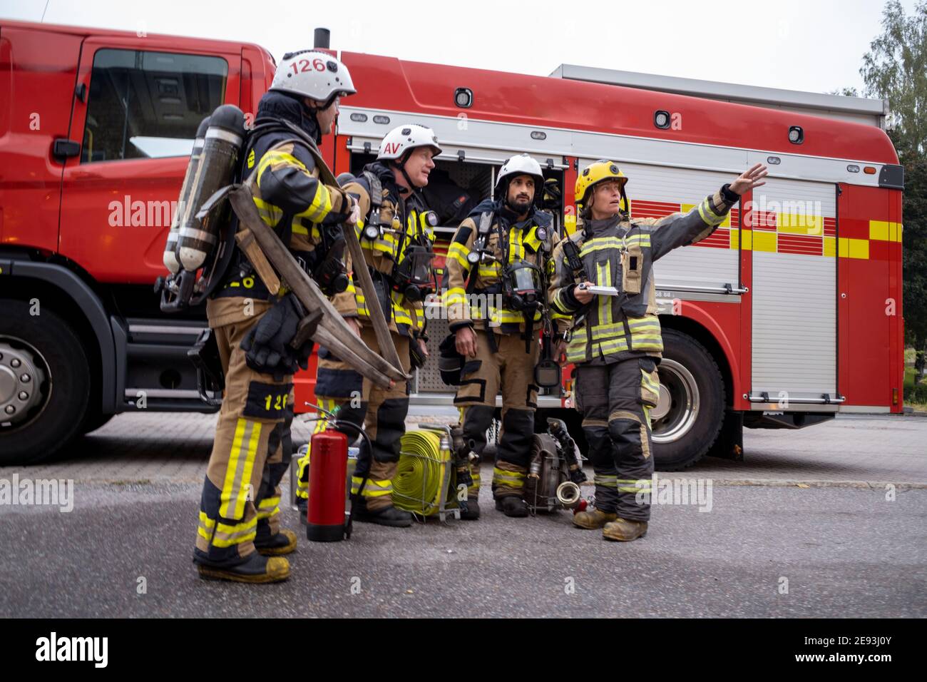 Firefighters team in front of fire engine Stock Photo - Alamy